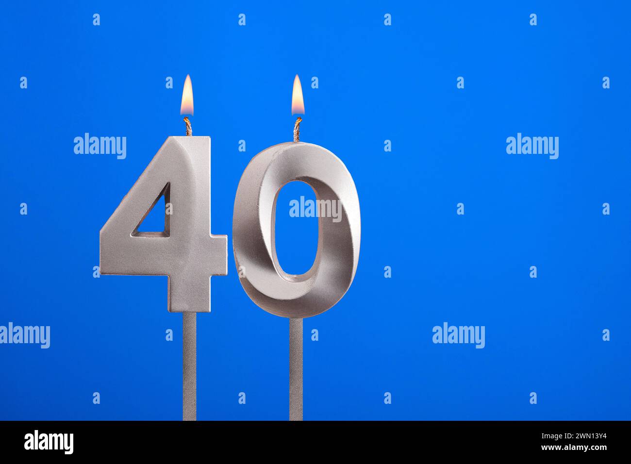 Birthday number 40 - Candle lit on blue background Stock Photo - Alamy