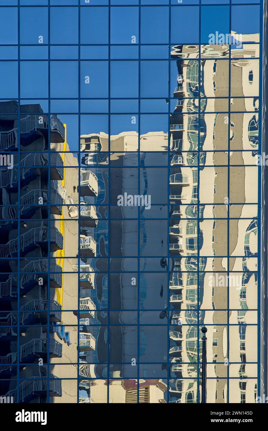 Mirrored reflections of high-rise residential buildings in glass walled ...