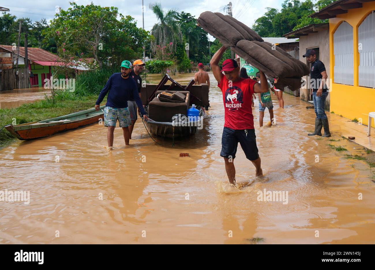 Residents recover furniture from their flooded homes in Cobija, Bolivia ...