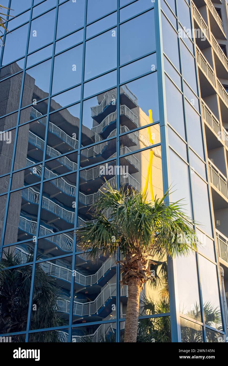 Mirrored reflections of high-rise residential buildings in glass walled ...