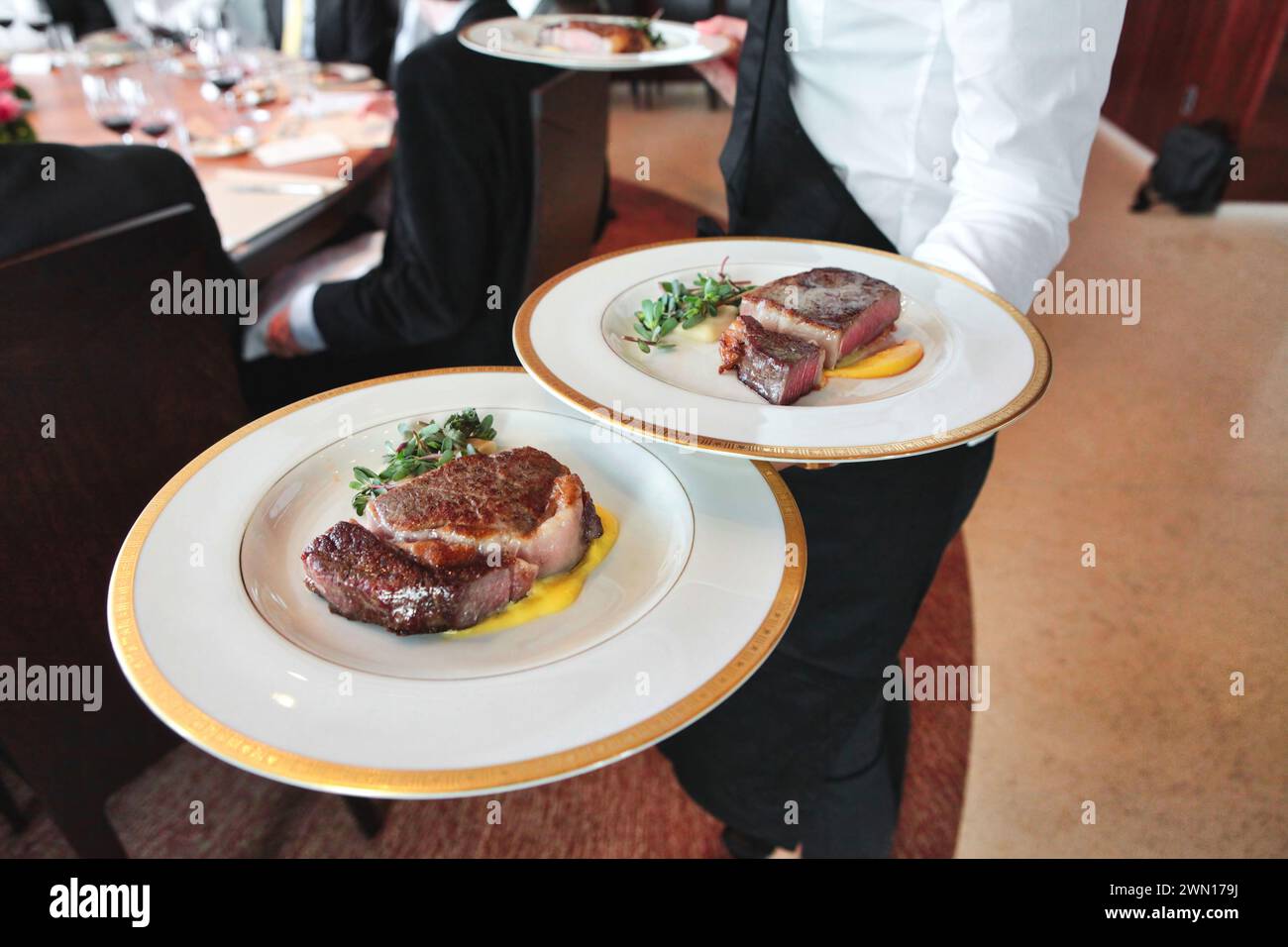 Waiter serving steak restaurant close hi-res stock photography and ...