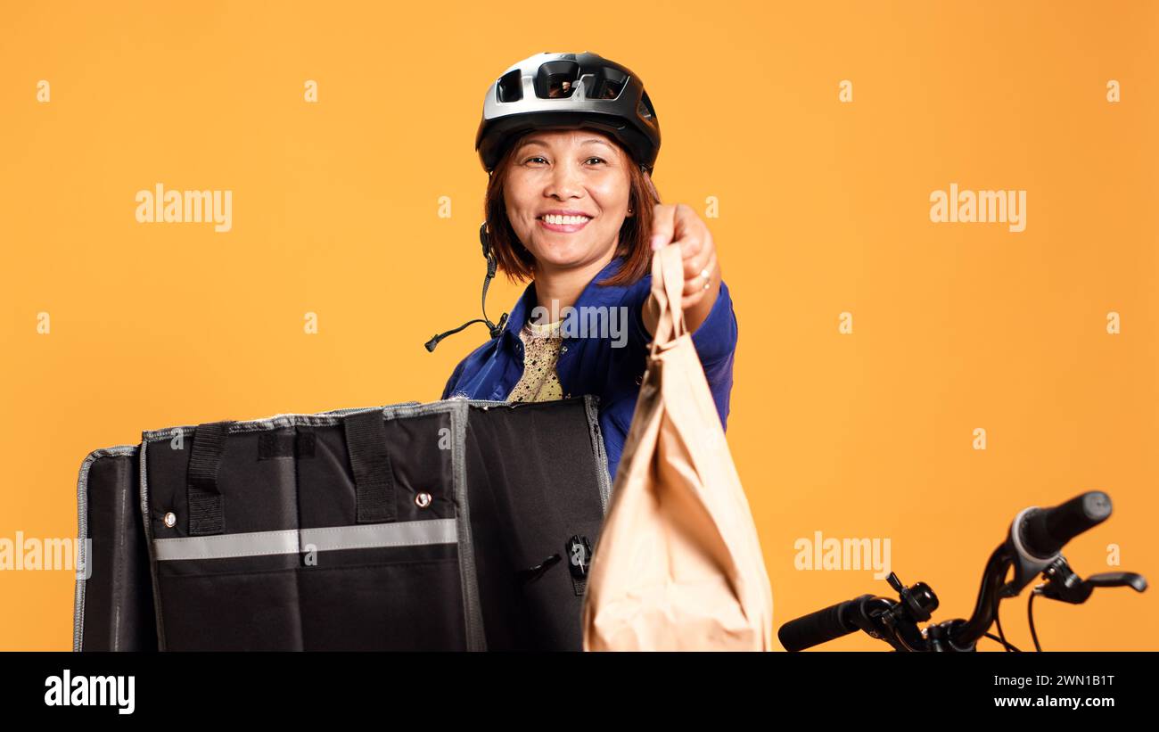Handheld close up shot of BIPOC woman taking takeaway meal bag out of ...