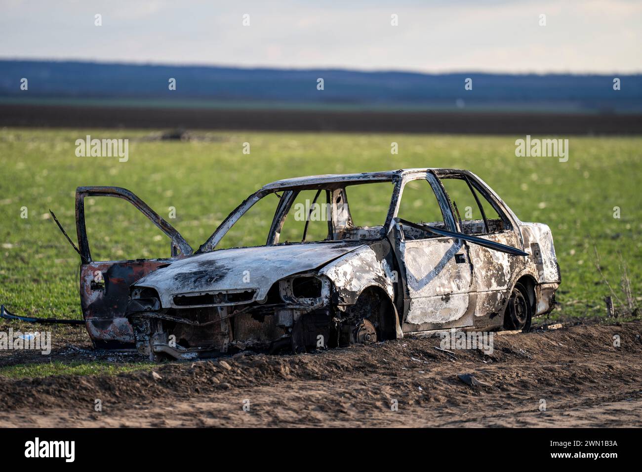 A burned out car. Burnt car in the field. Car fire, vehicle fire due to ...