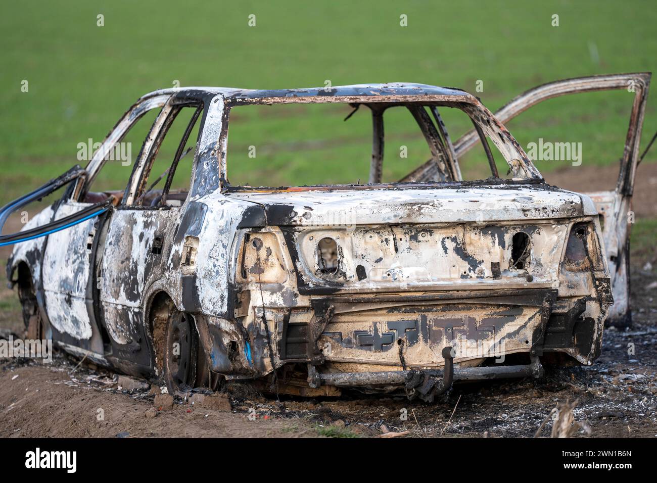 A burned out car. Burnt car in the field. Car fire, vehicle fire due to ...