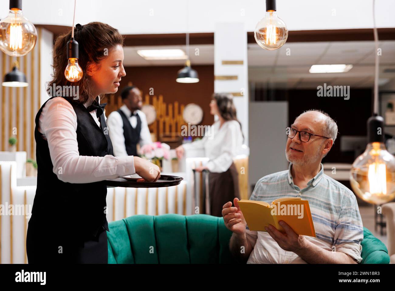 Reading woman sitting in hotel lounge hi-res stock photography and ...