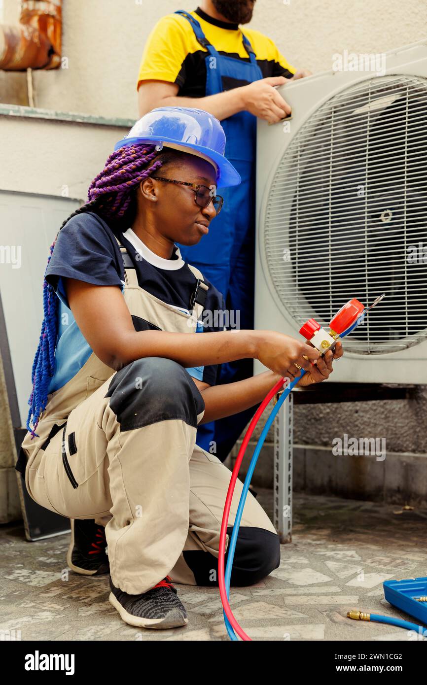 Close up of african american engineer holding manifold gauges used for ...