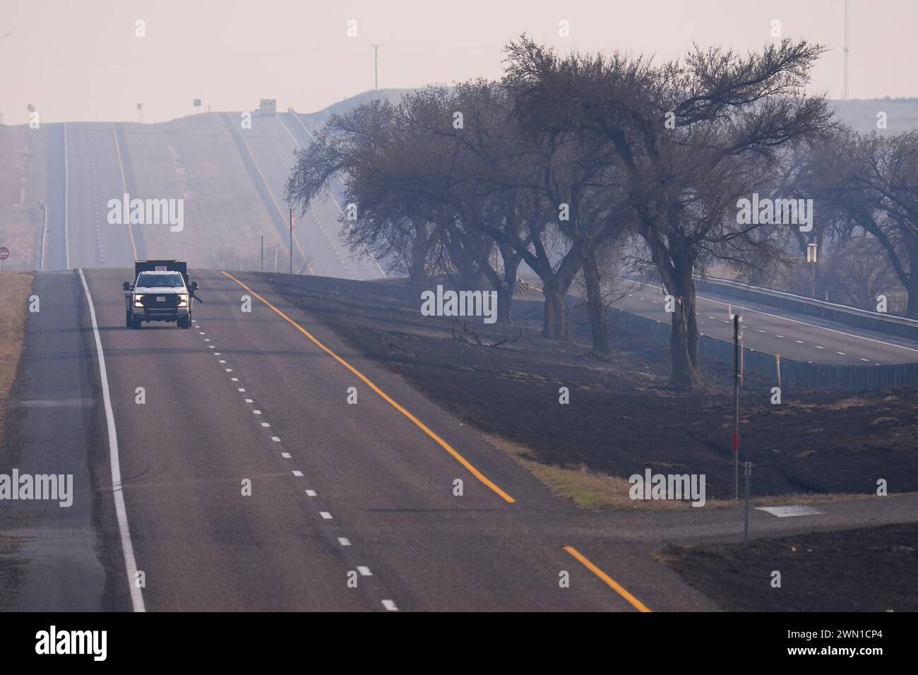 A vehicle rides northbound on Highway 83 near a charred area burned by ...
