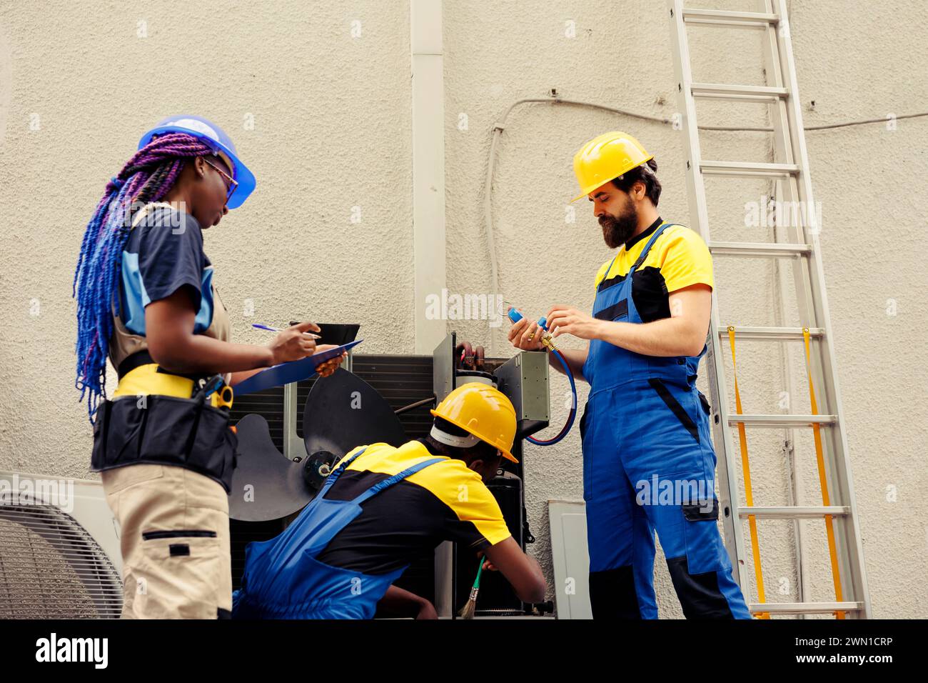 Diverse team commissioned to mend defective hvac system. Coworkers ...