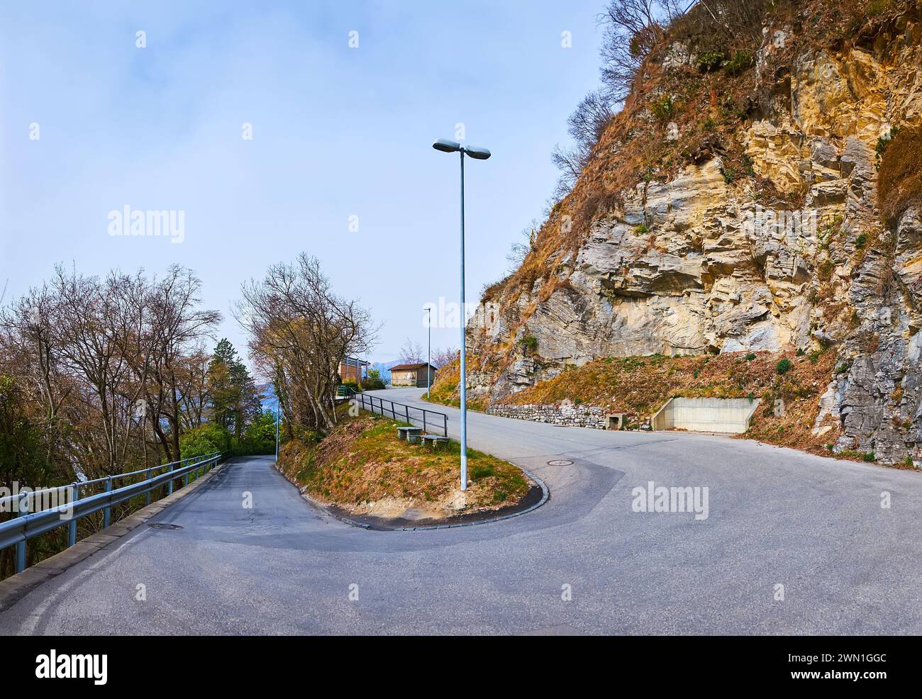 The mountain serpentine road, lined with forest and steep rock, leading ...