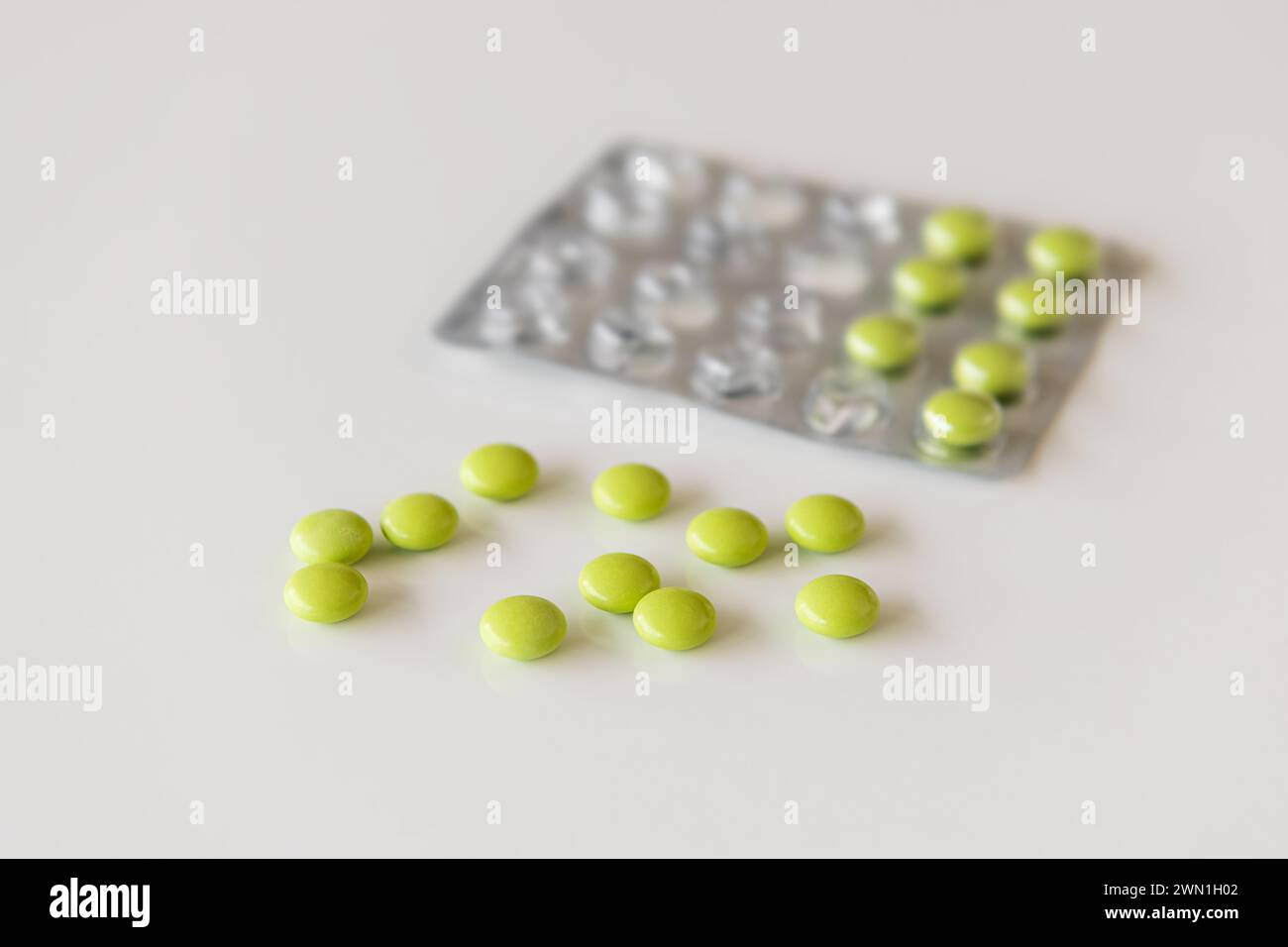 Medicine pills, drugs in different colours arranged on a white ...