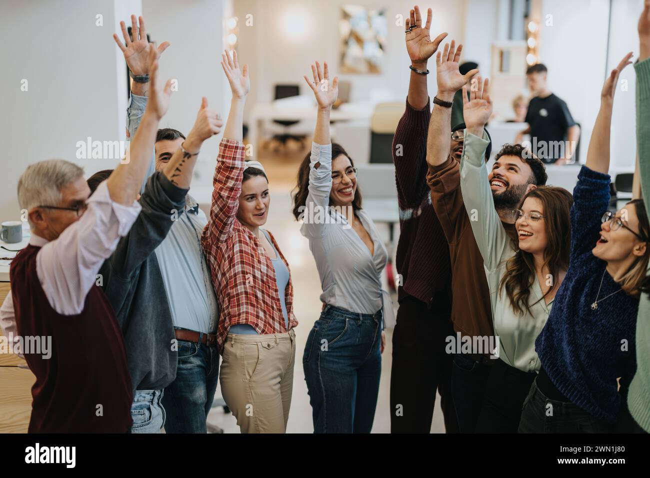 A multi generational team celebrates a success in a modern office ...