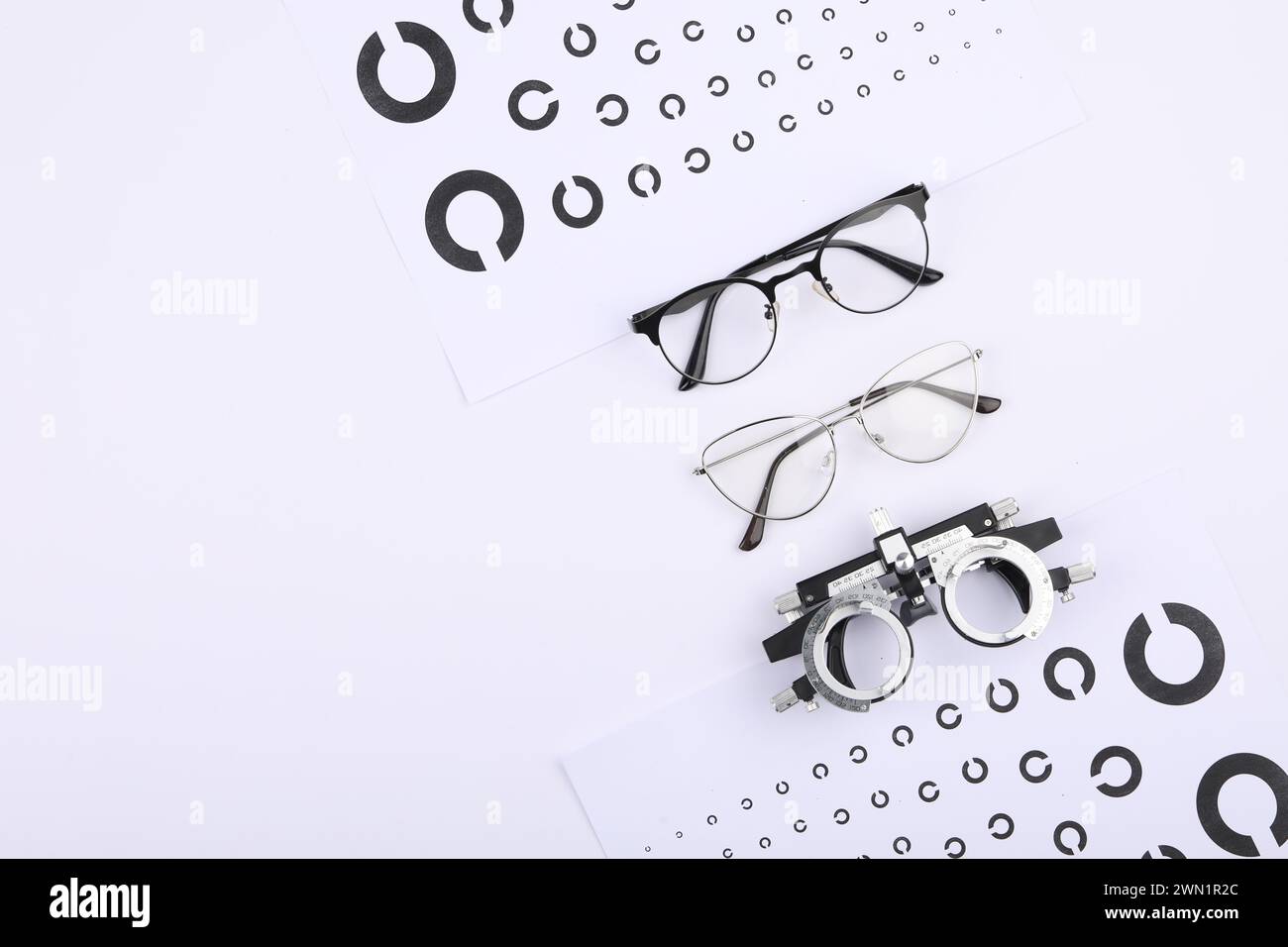 Vision test charts, glasses and trial frame on white background, flat ...
