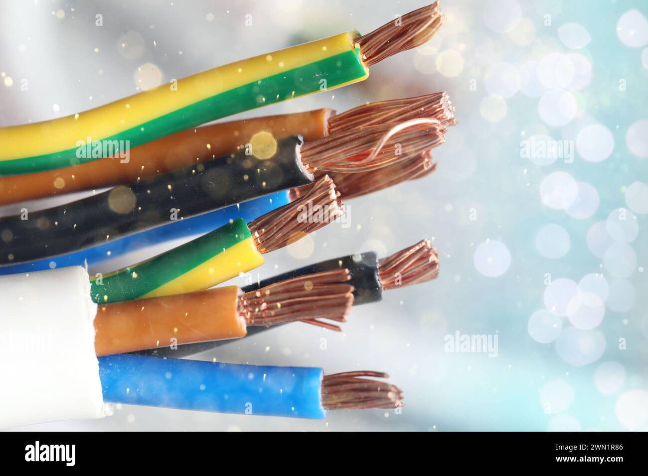 Colorful electrical wires against background with blurred lights ...