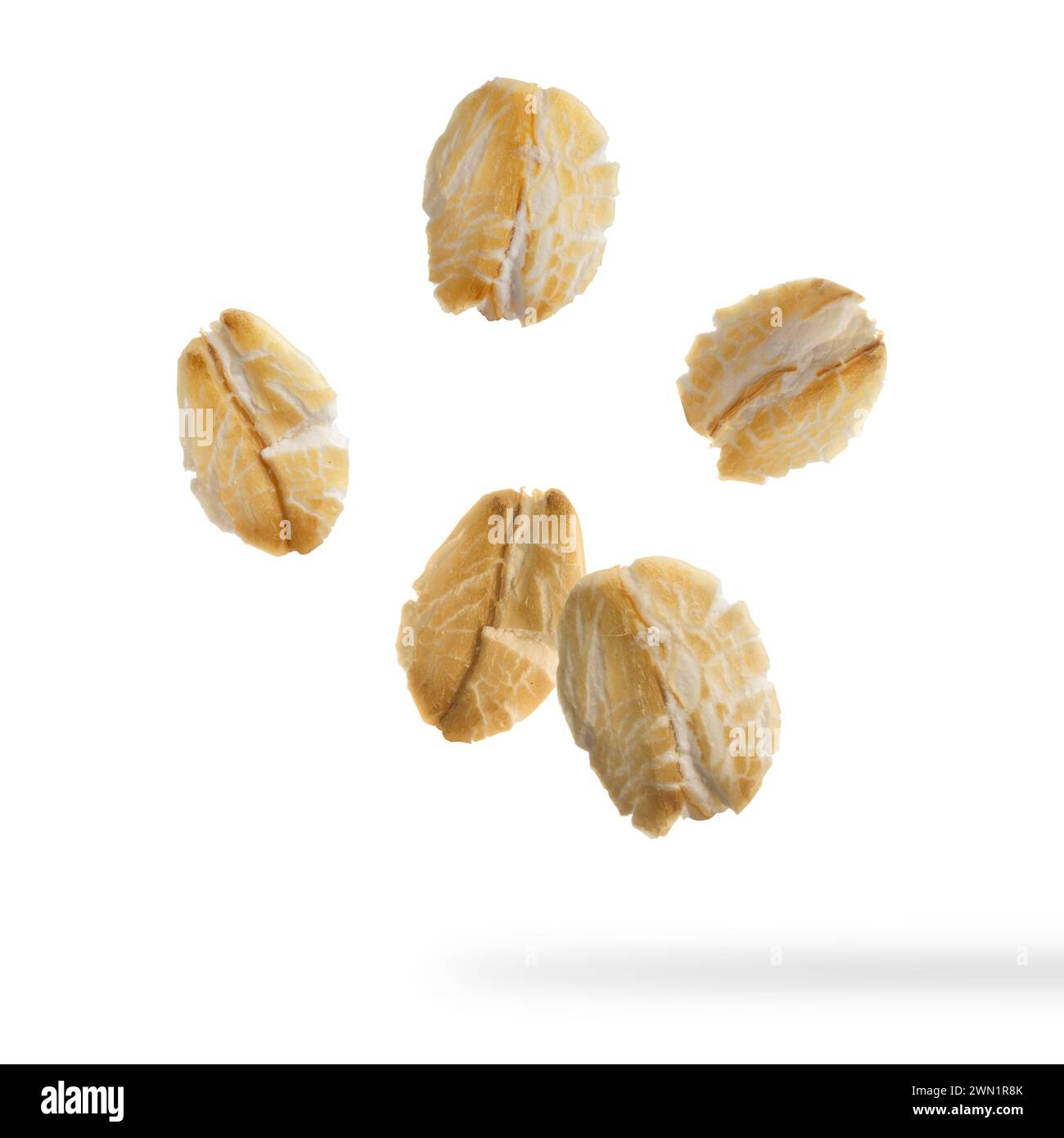 Rolled oat flakes falling on white background Stock Photo - Alamy