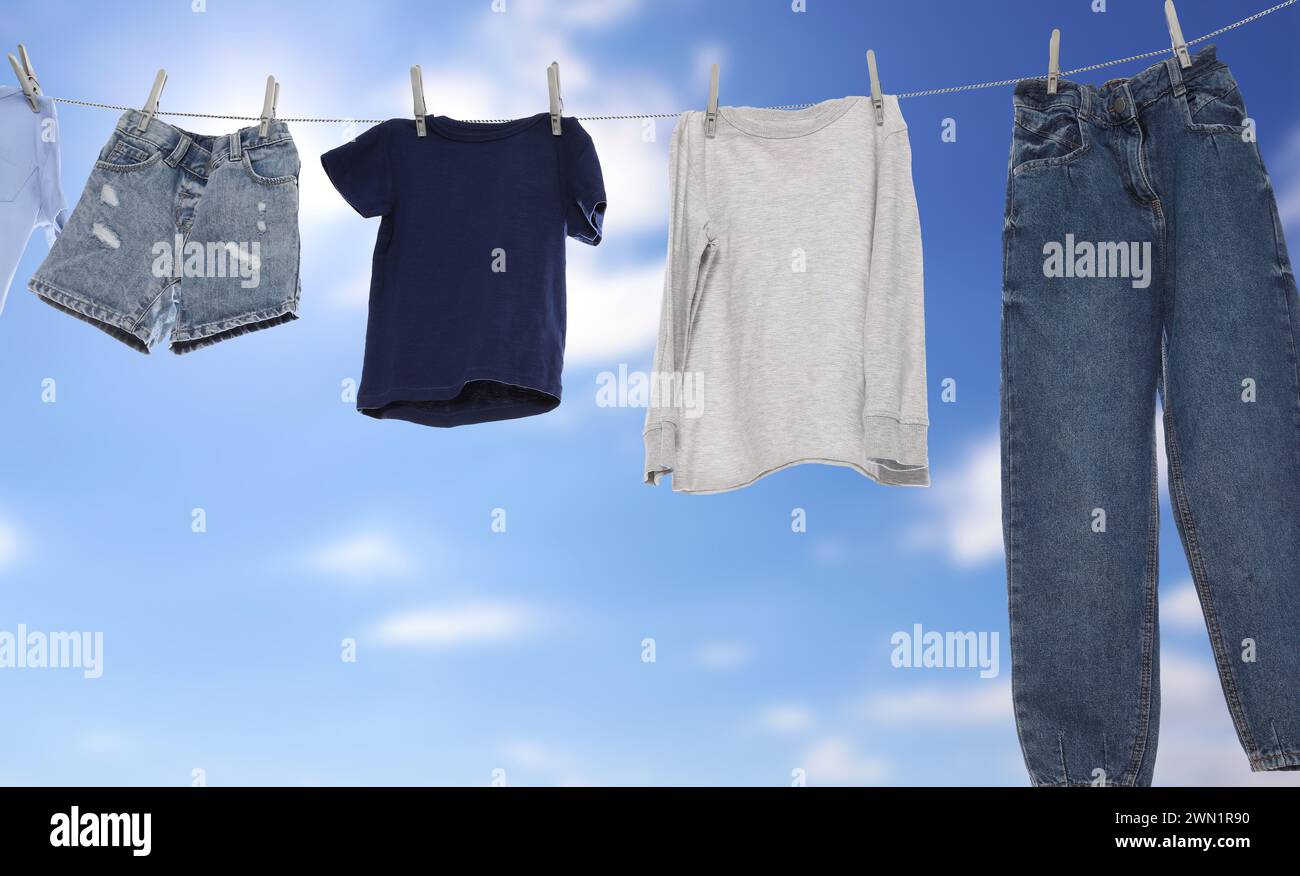 Different clothes drying on washing line against blue sky, banner ...