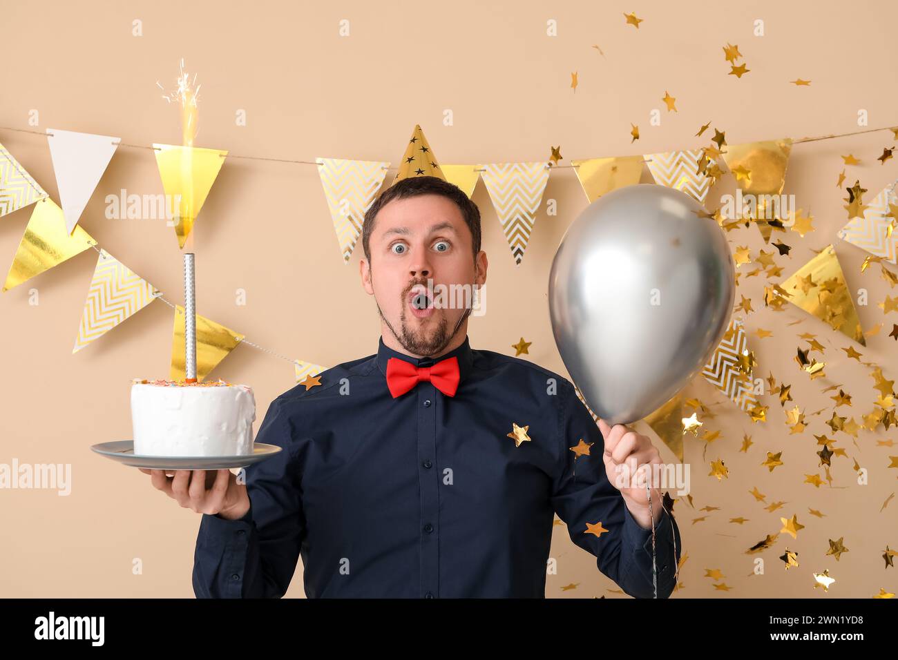 Surprised man with birthday cake and balloon on beige background Stock ...