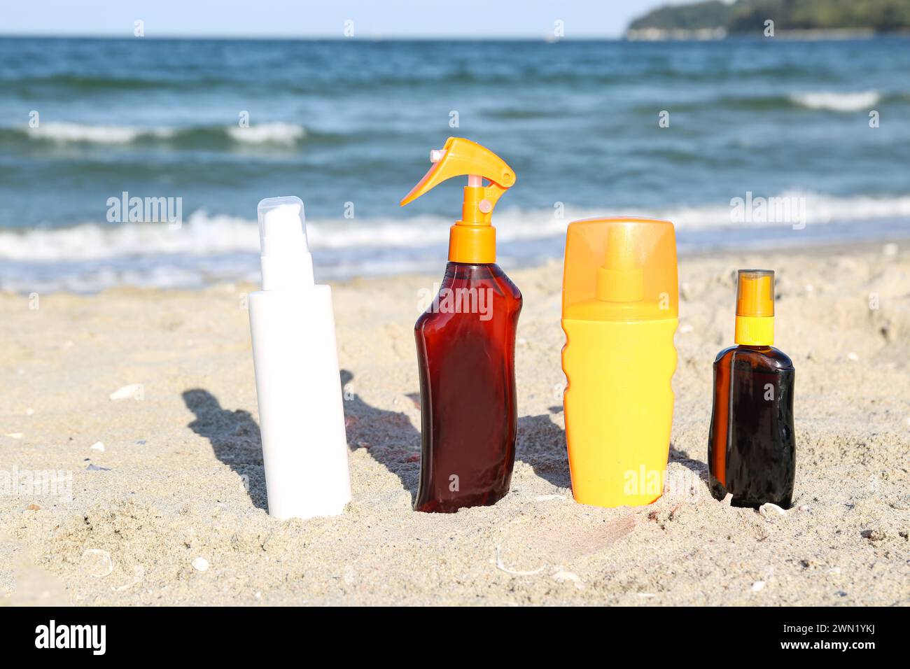 Bottles of sunscreen cream on sand near ocean at beach Stock Photo - Alamy