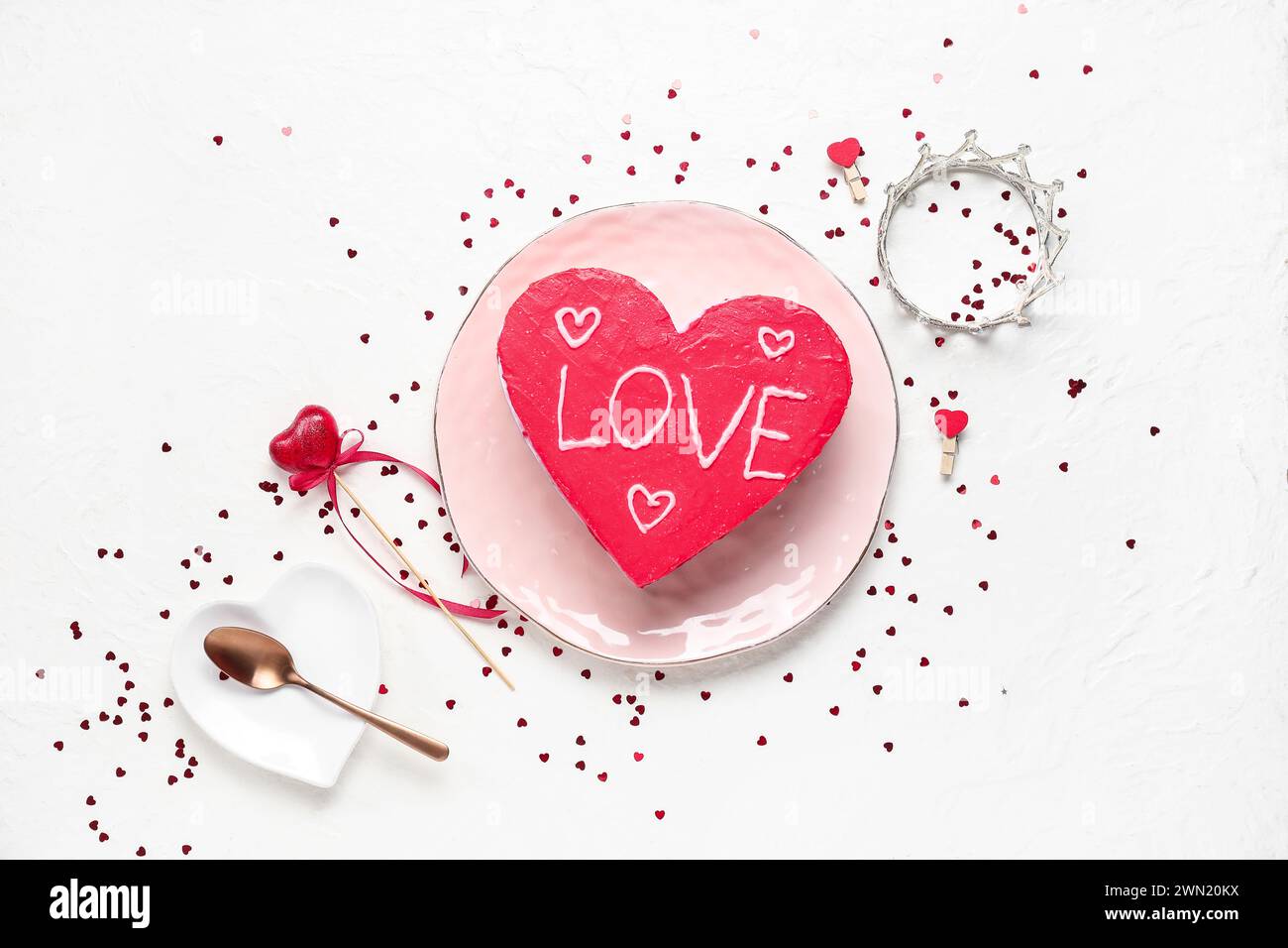 Heart-shaped bento cake with crown and confetti on white background ...