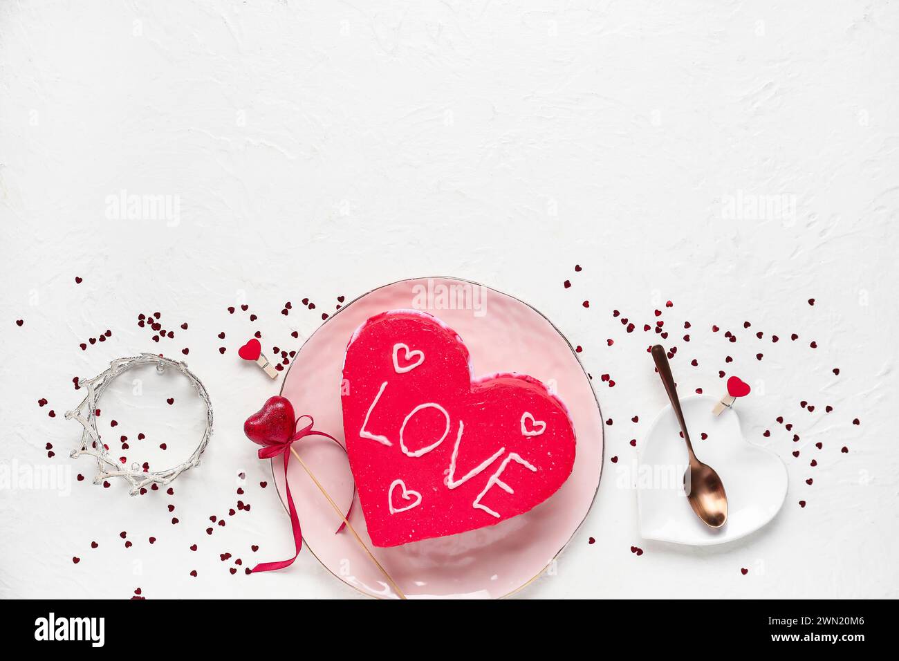 Heart-shaped bento cake with crown and confetti on white background ...