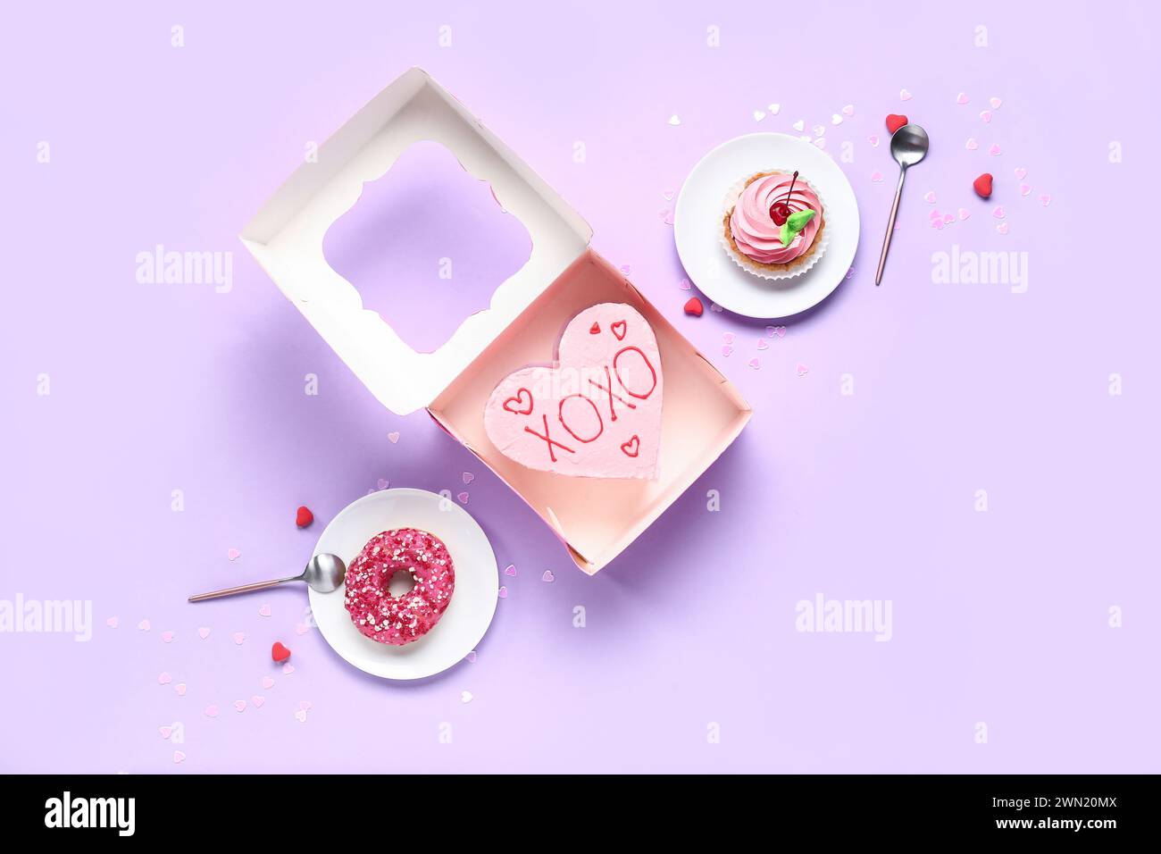 Heart-shaped bento cake with donut and cupcake on purple background ...