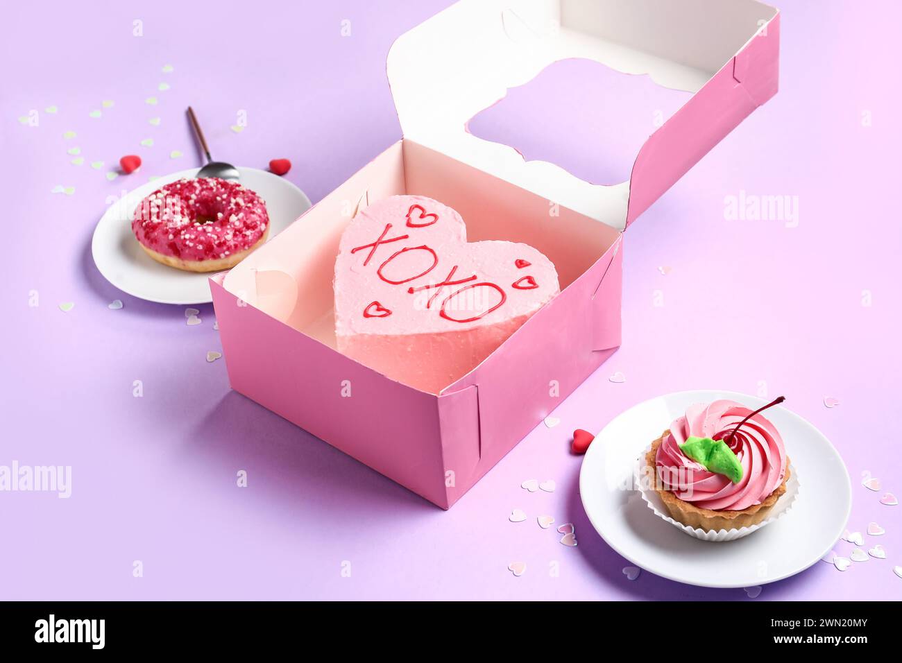 Heart-shaped bento cake with donut and cupcake on purple background ...