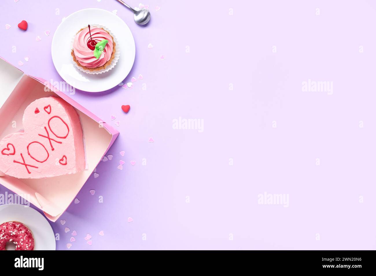 Heart-shaped bento cake with donut and cupcake on purple background ...
