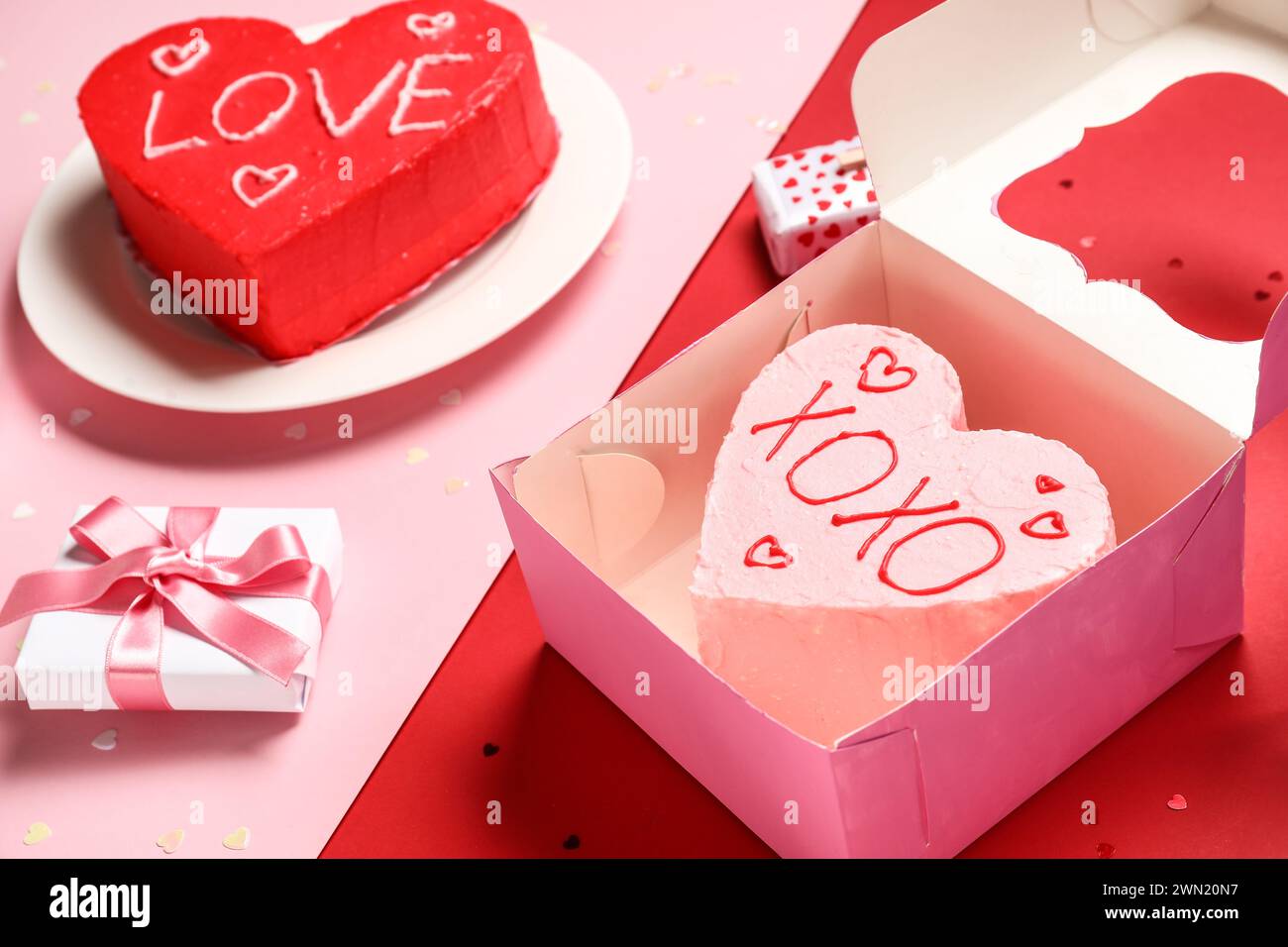 Heart-shaped bento cakes with gift boxes on color background. Valentine ...