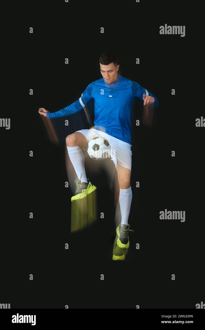 Male footballer playing with ball in motion on dark background Stock ...