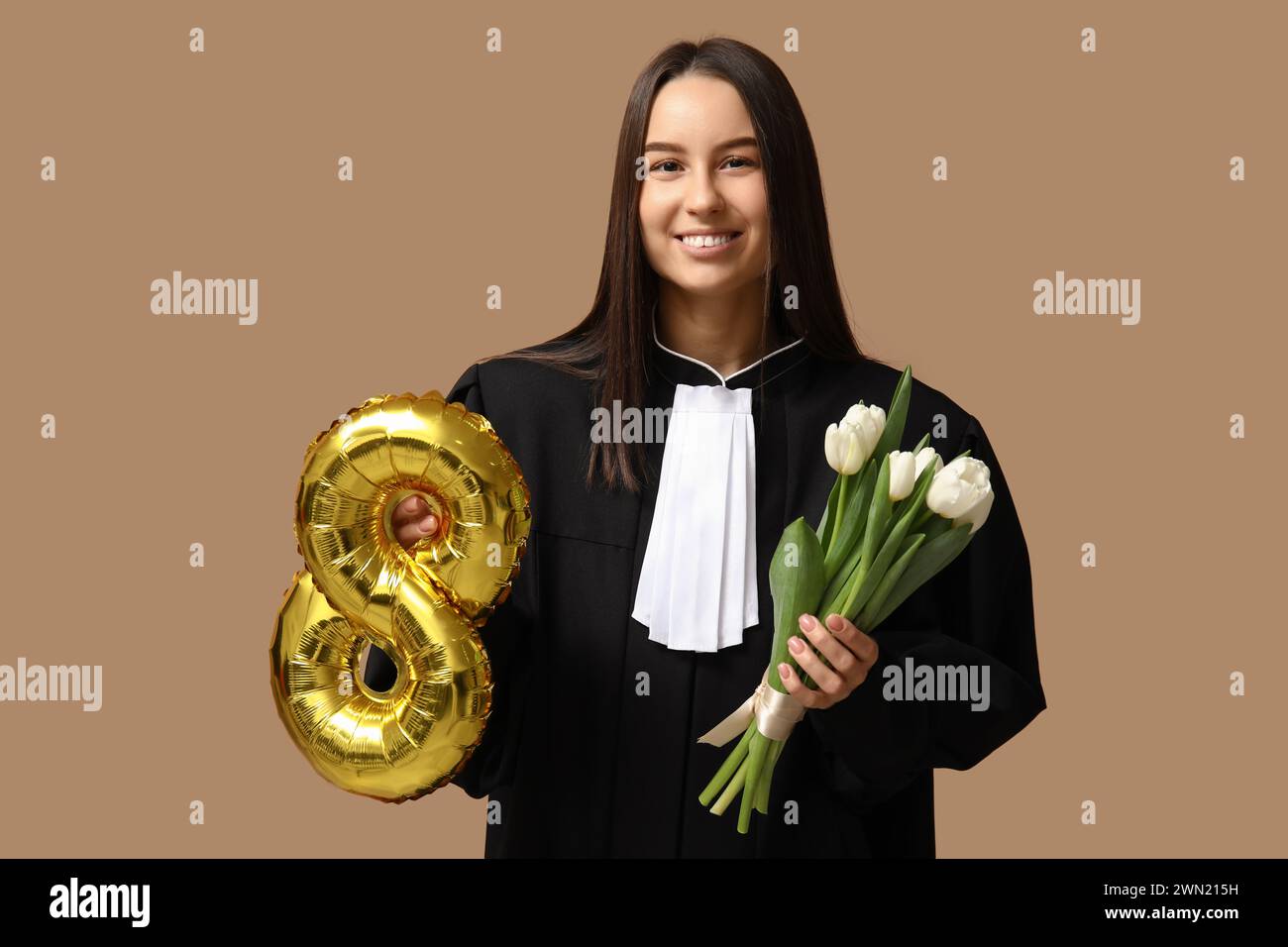 Young female judge with balloon in shape of figure 8 and white tulips ...