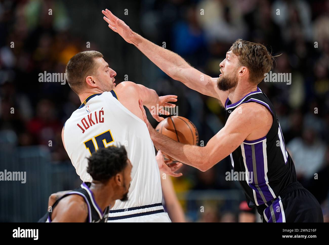 Denver Nuggets center Nikola Jokic, left, passes the ball as Sacramento Kings forward Domantas ...