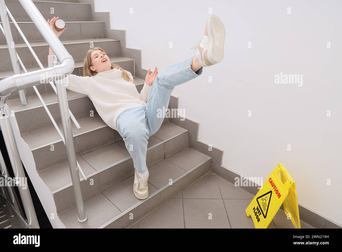 Young woman fell down on wet steps in stairway. Trauma concept Stock ...