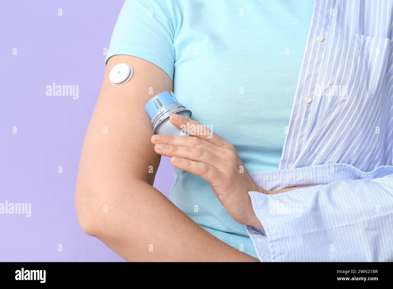 Woman with glucose sensor for measuring blood sugar level and ...