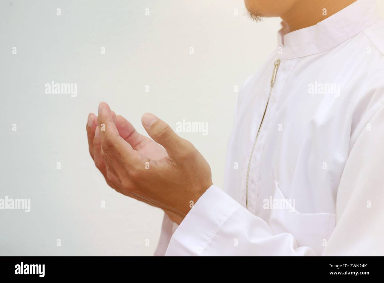 Front view of Muslim man raising hands and praying in mosque, ramadan ...