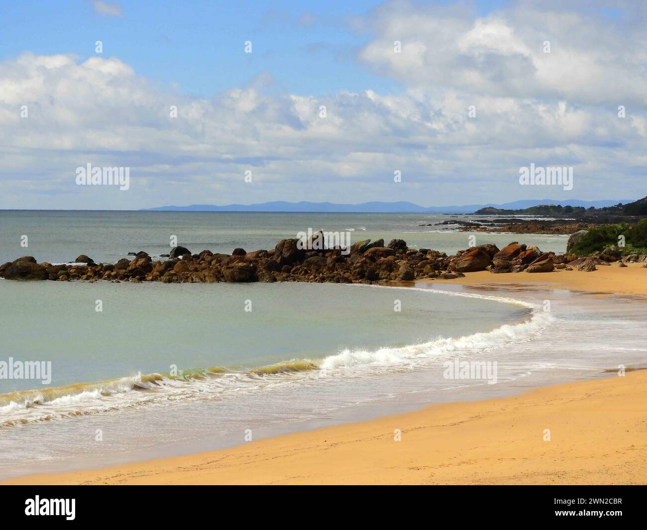 picturesque beach on a sunny day in the seaside town of penguin along ...