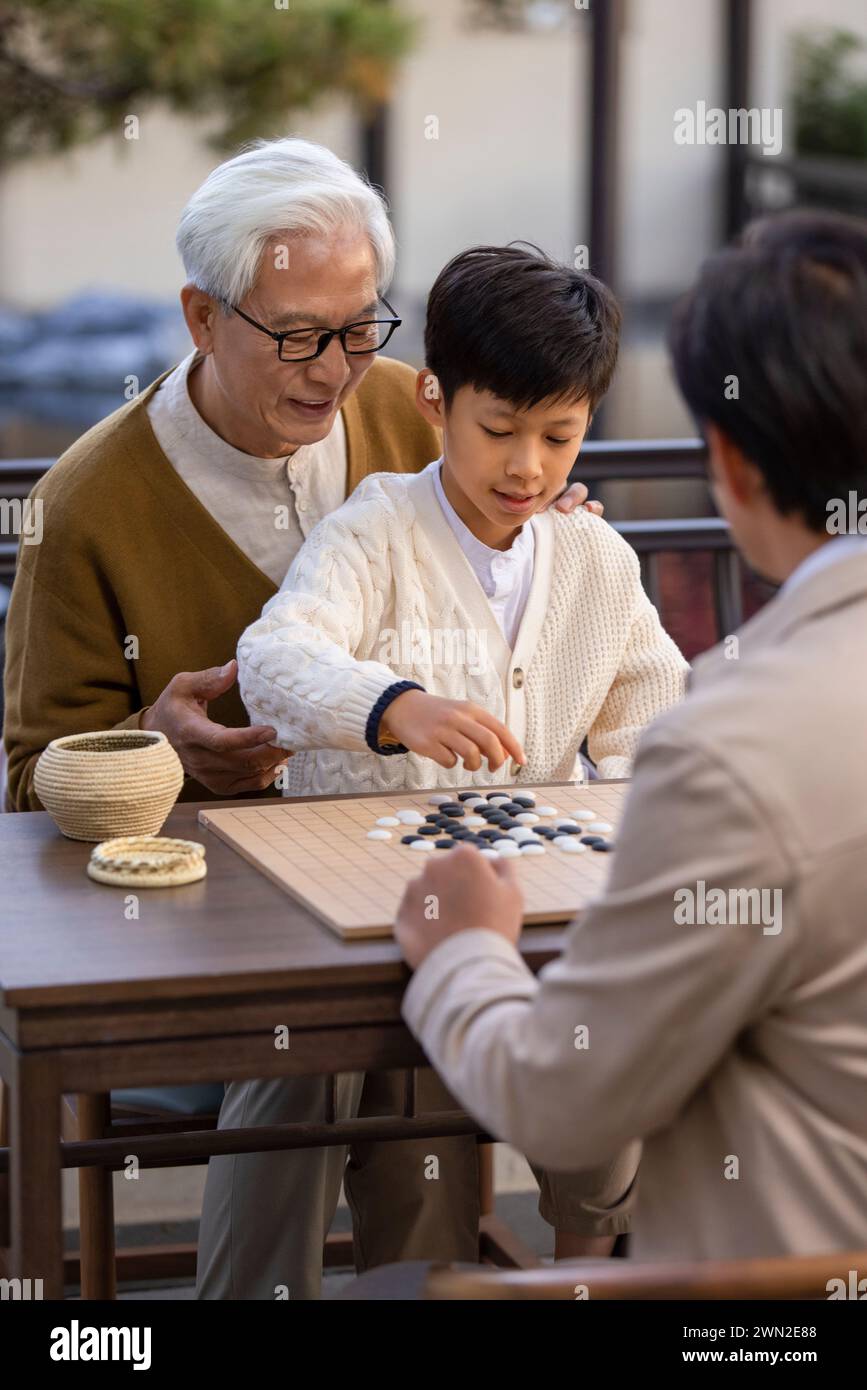 Male Members of the Family Playing Go Stock Photo - Alamy