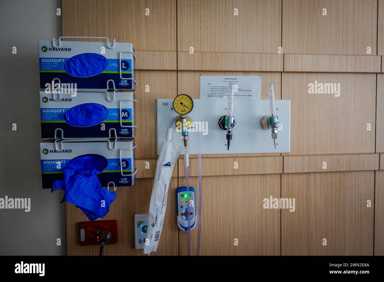 Medical supplies such as disposable gloves, syringes, and tubes mounted ...