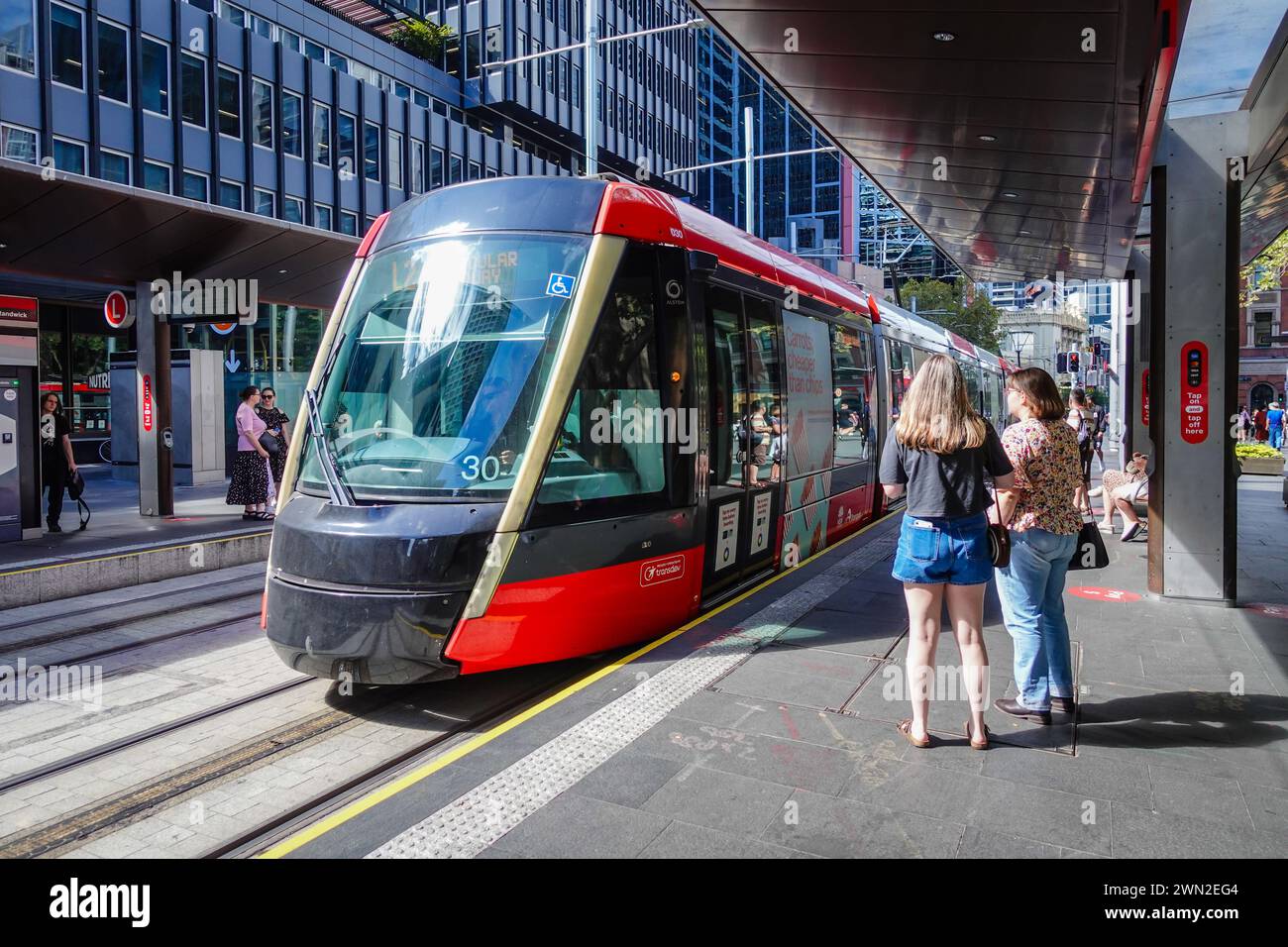 Commuters waiting for the Sydney Light Rail at a light rail station in ...
