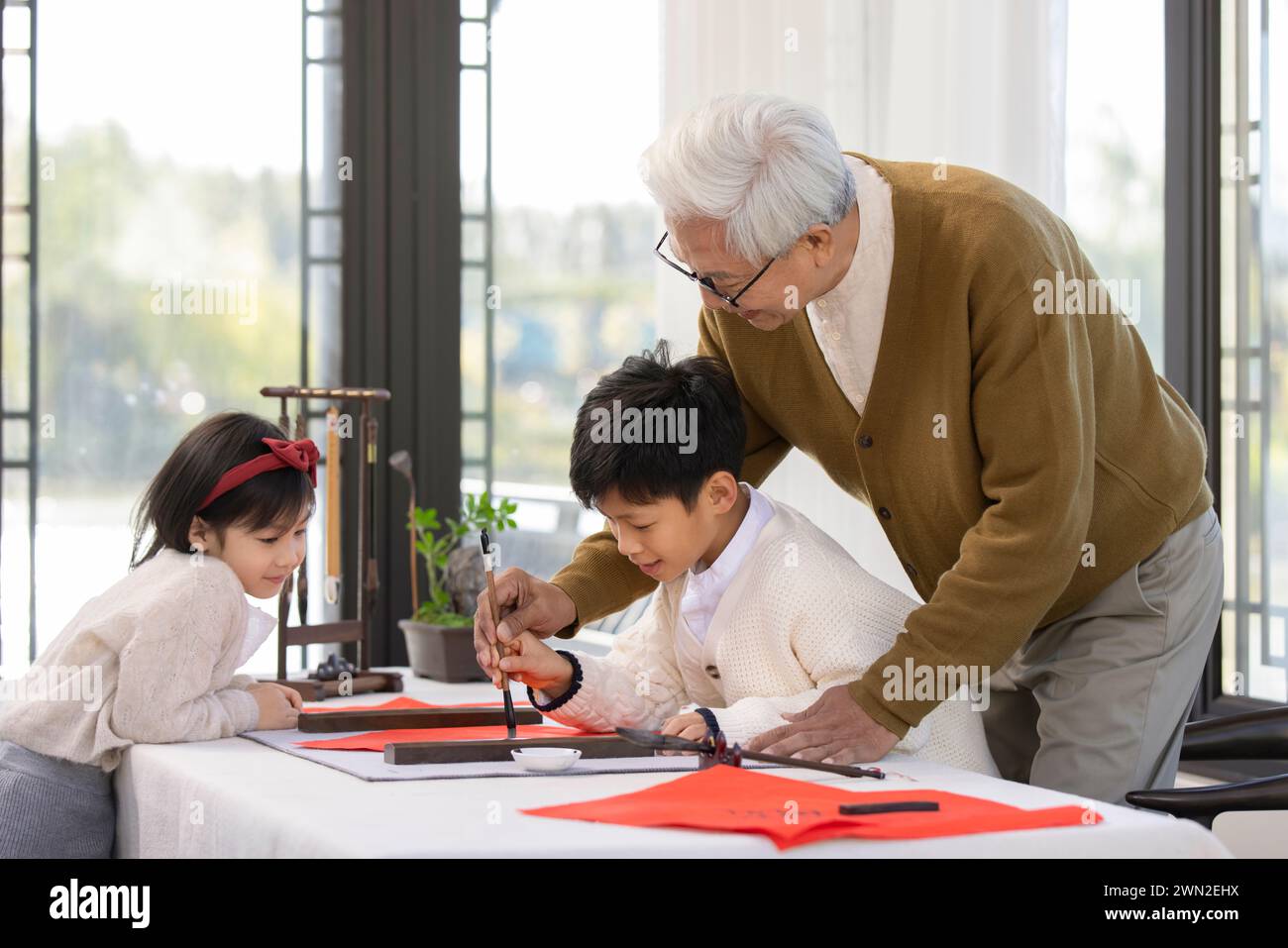 Grandfather and Grandkids Writing New Year Couplets Stock Photo - Alamy