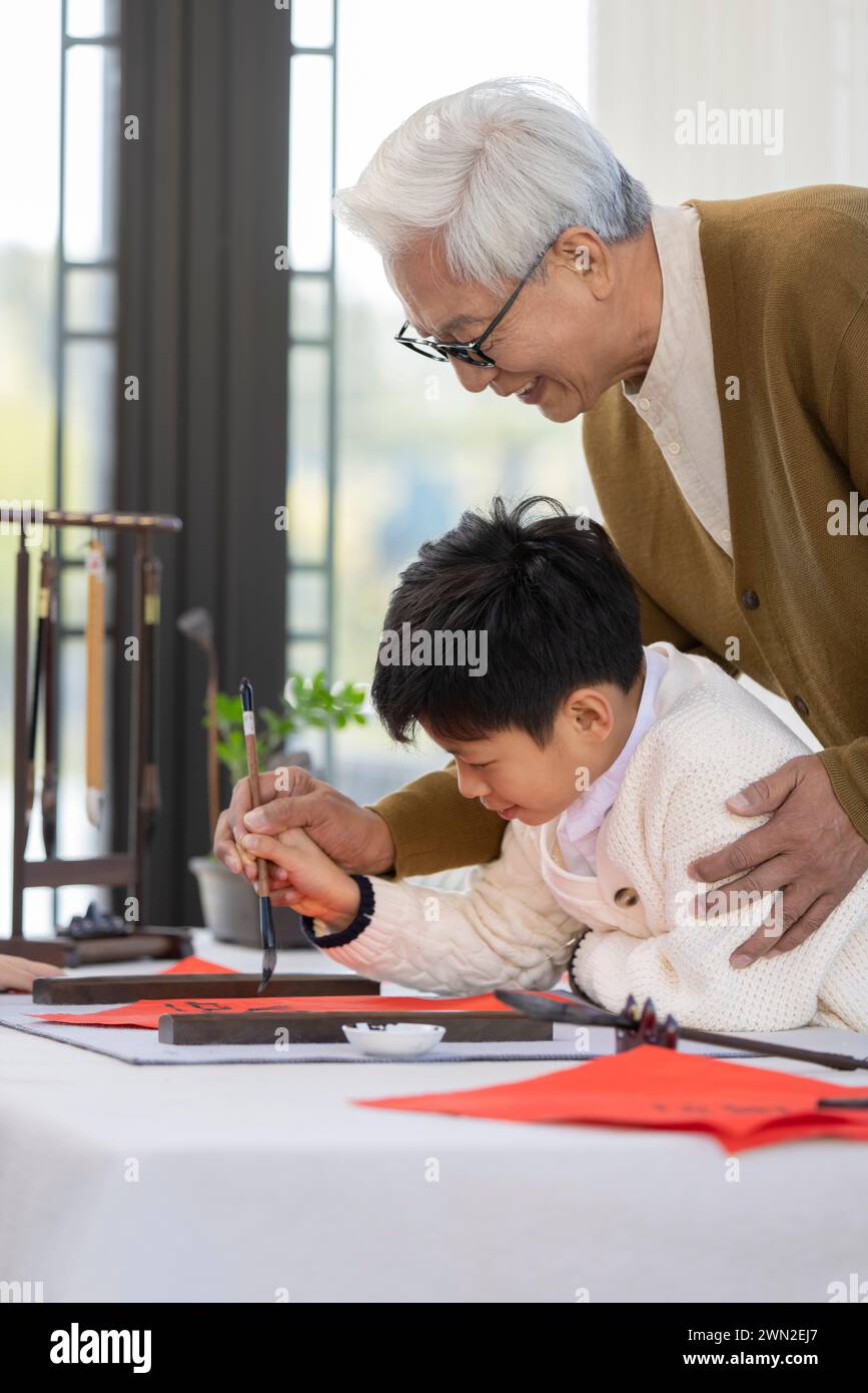 Grandfather and Grandson Writing New Year Couplets Stock Photo - Alamy