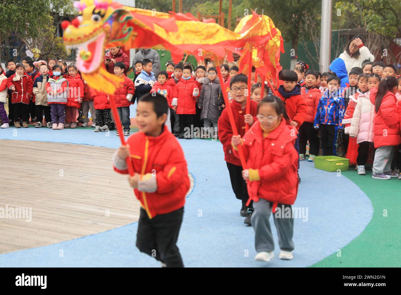 Children from a kindergarten perform dragon and lion dance to welcome ...