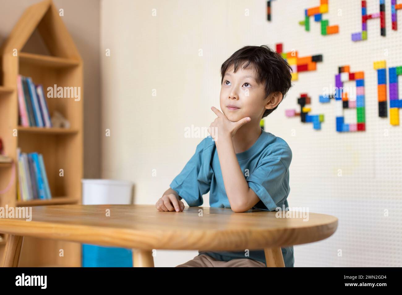 Cute boy thinking in classroom Stock Photo - Alamy