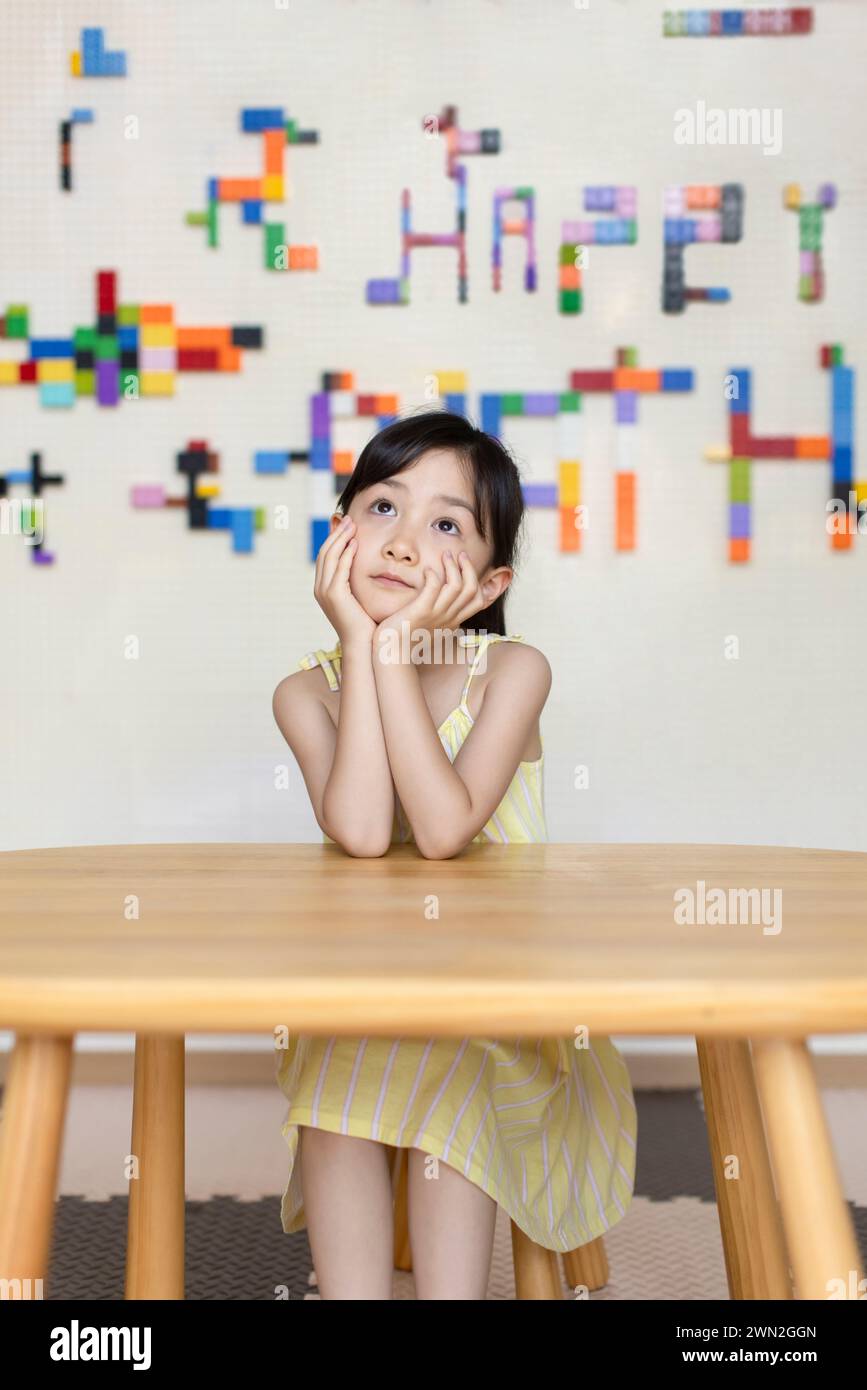 Cute girl thinking in classroom Stock Photo - Alamy