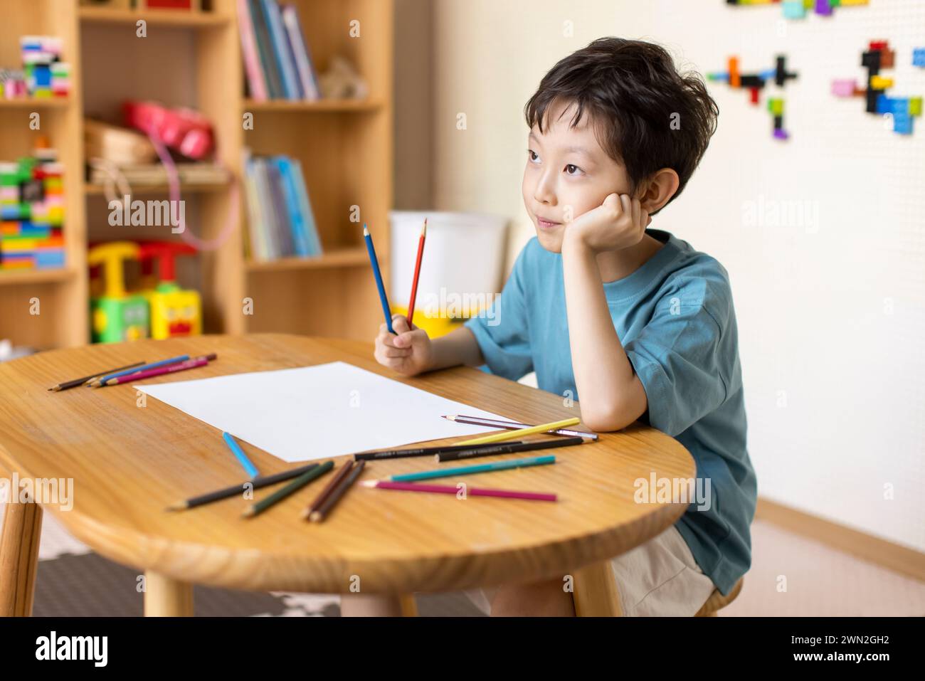 Cute boy thinking in classroom Stock Photo - Alamy