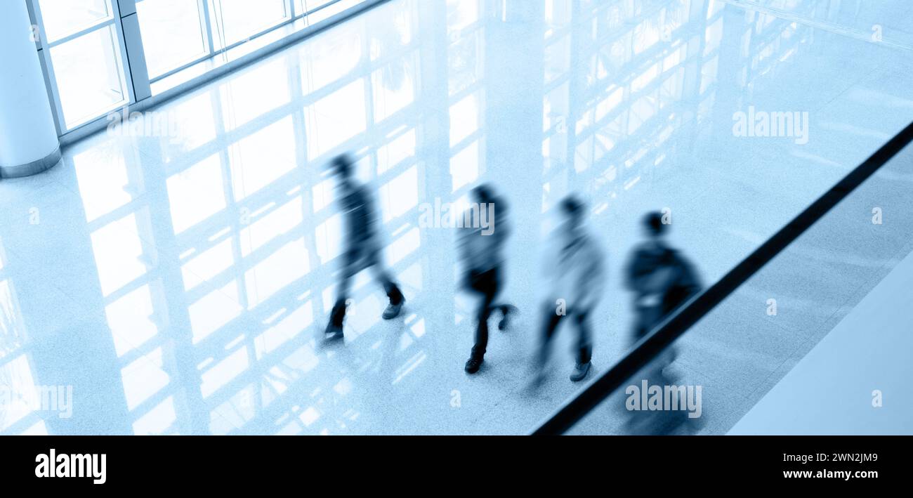 Group of business people walking in modern office building Stock Photo ...