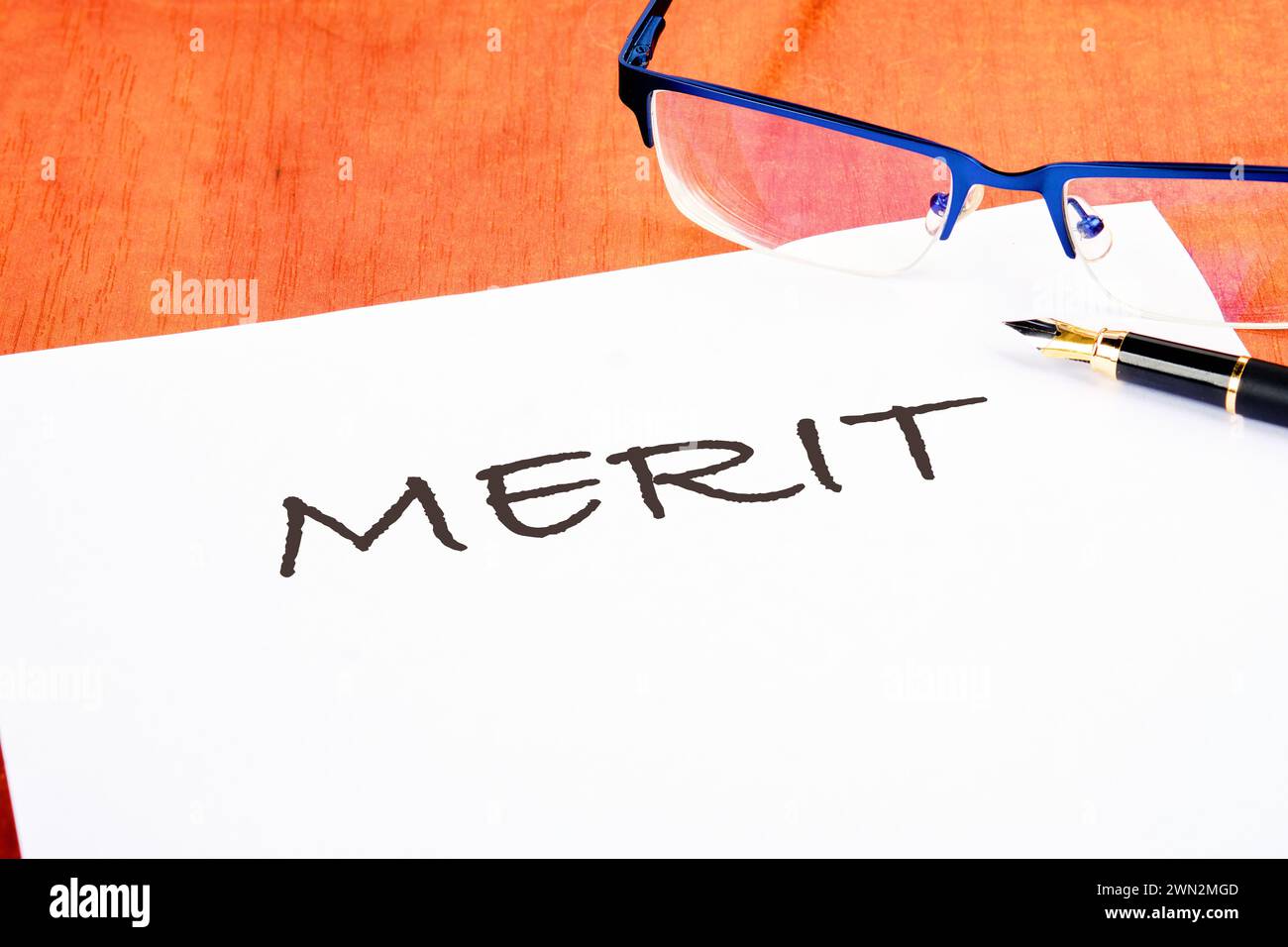 Business and merit concept. MERIT written on a white piece of paper on ...