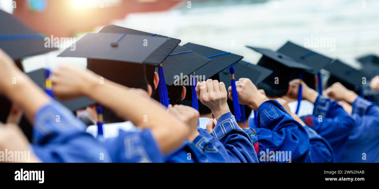 Back of graduates put hands up in a row during commencement Stock Photo ...