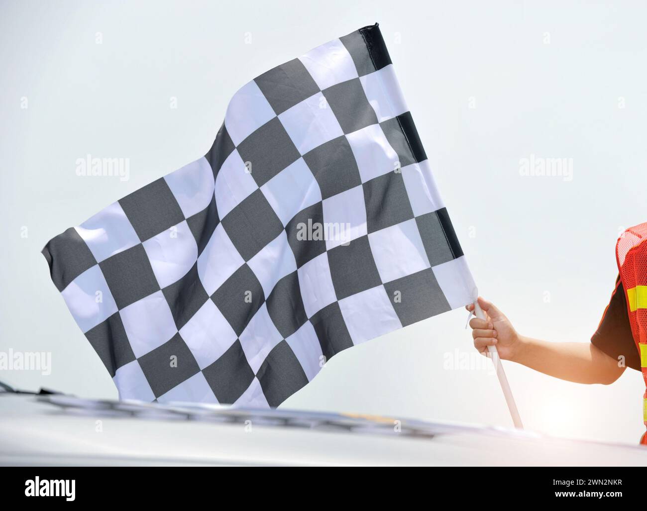 Checkered race flag in hand against white background Stock Photo - Alamy