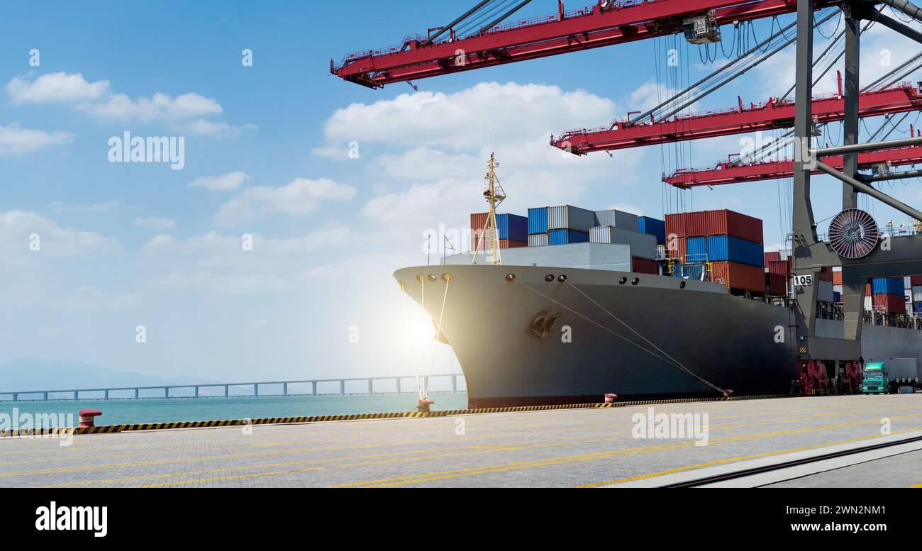 Container ship in the harbor with working crane bridge Stock Photo - Alamy
