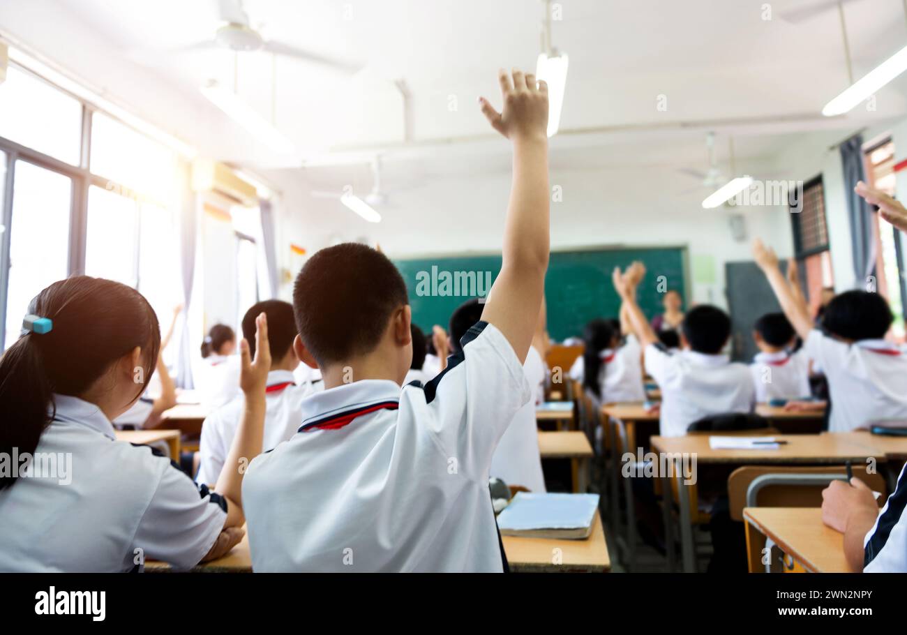 Group of raised hands in class of middle school Stock Photo - Alamy