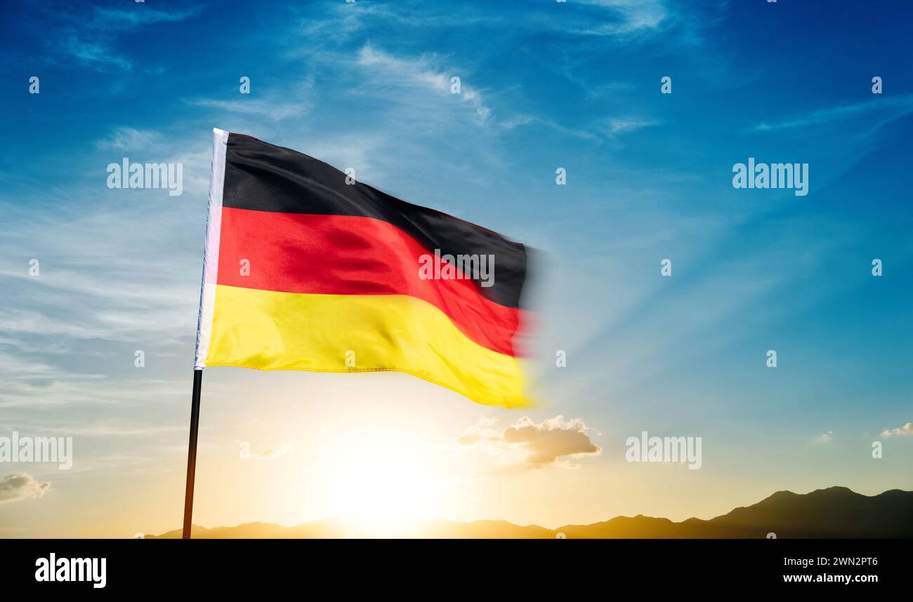 German flag waving against sunrise sky background Stock Photo - Alamy